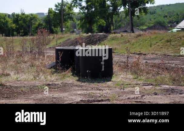 Black rectangular object in an open field, surrounded by dry grass and ...