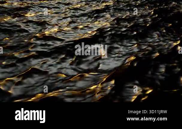 looping animation of black liquid with gold shimmer. Abstract cycled ...