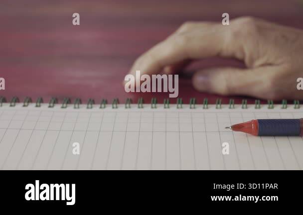 Female right hand tapping fingers on desk near notebook with pencil ...