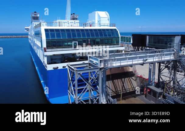 The aft deck of an elegant blue ferry moored at a dock and its boarding ...