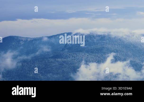 Rugged mountain covered in snow, cold air drifting over rocky ridges ...