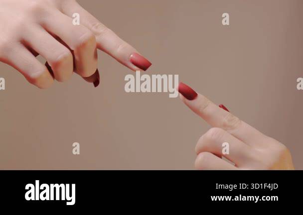 Finger taps another fingertip, accentuating red nail tip detail and ...
