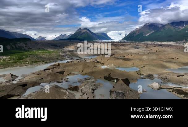 Distancing from the rugged ground with puddles of water. Clouds cover ...