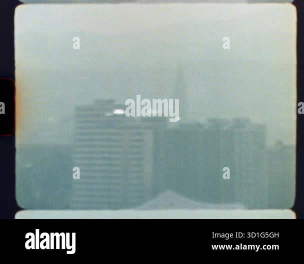 Authentic Super 8mm film footage captures a hazy city skyline, with ...