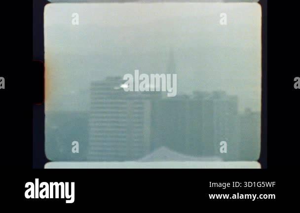 Authentic Super 8mm film footage captures a hazy city skyline, with ...