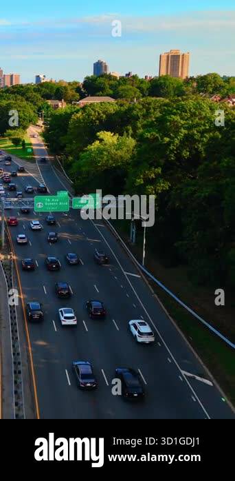 Busy highway with exit signs and contrast between trees and buildings ...