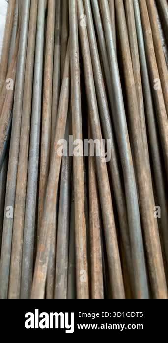 4K close-up of stacked rusty steel rebar rods with rough corrosion ...