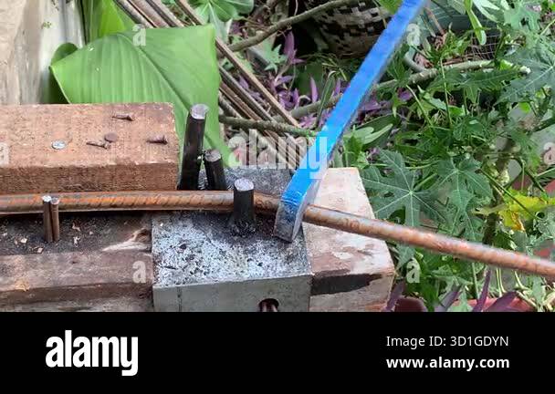 4K footage of construction worker bending steel rebar with tool to form ...
