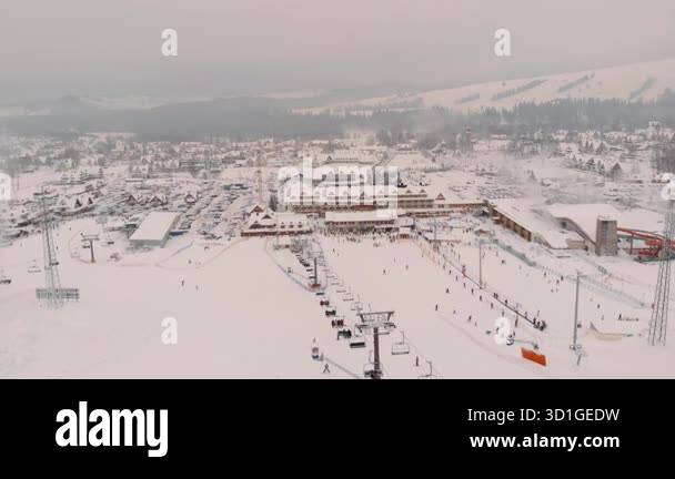 Aerial perspective reveals a winter wonderland ski resort, with skiers ...