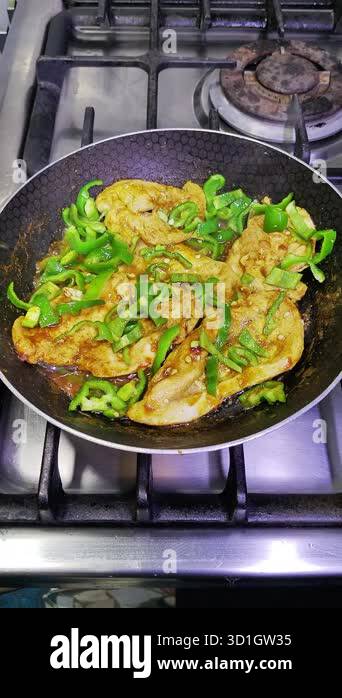 Chest Chicken slices with corn oil and green pepper in a frying pan on ...