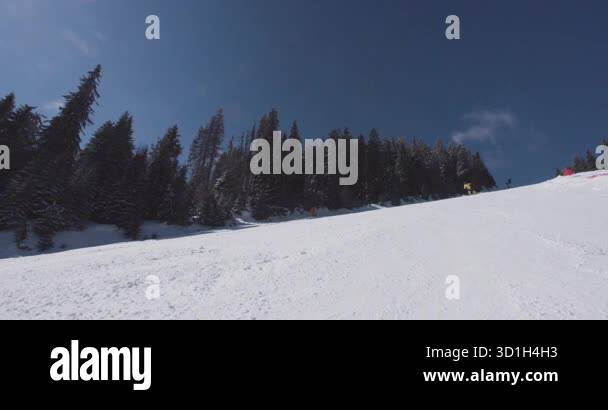 A skier gracefully descends a stunning white slope surrounded by tall ...