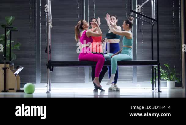 Four women engage in a collaborative fitness session, performing ...