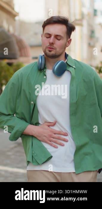 Caucasian young man traveler feeling sudden strong abdominal stomach ...