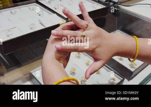 closeup of hand wearing two gold rings with diamond solitaire at ...