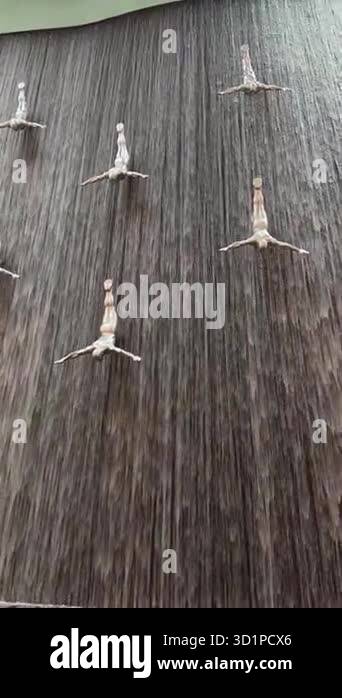 Dubai, UAE - Aug 18 2025: Artistic indoor waterfall with silver human ...