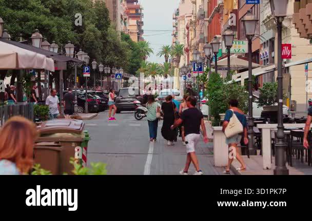 People walking along the historic waterfront in Taranto old town at ...