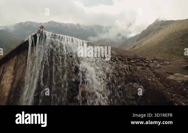 Waterfall cascading from a concrete structure in the Atlas Mountains ...