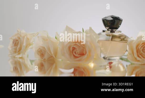 An elegant perfume bottle with a black cap is surrounded by beautiful ...