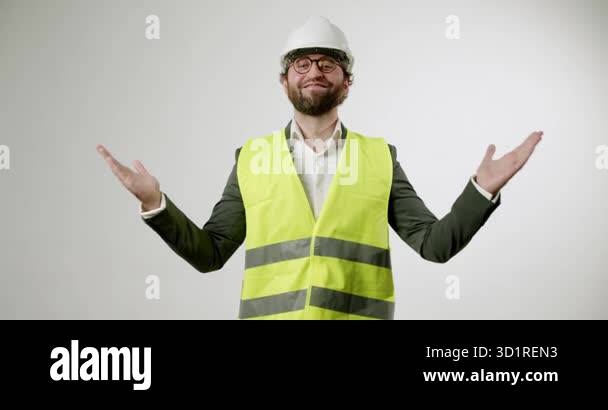A cheerful engineer or architect wearing a hard hat and safety vest ...