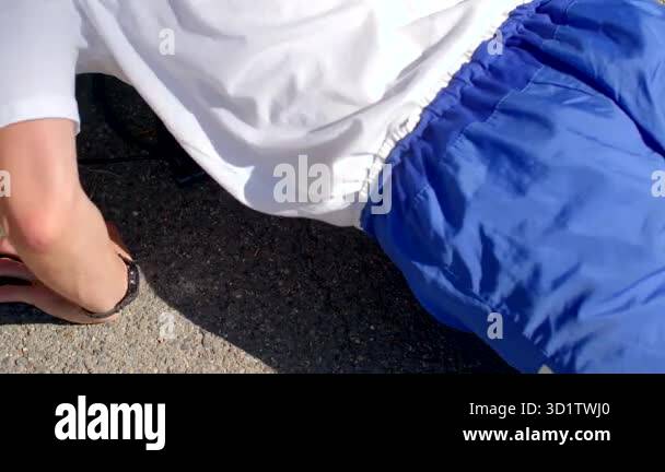 An individual engaging in a series of pushups on a sturdy asphalt ...