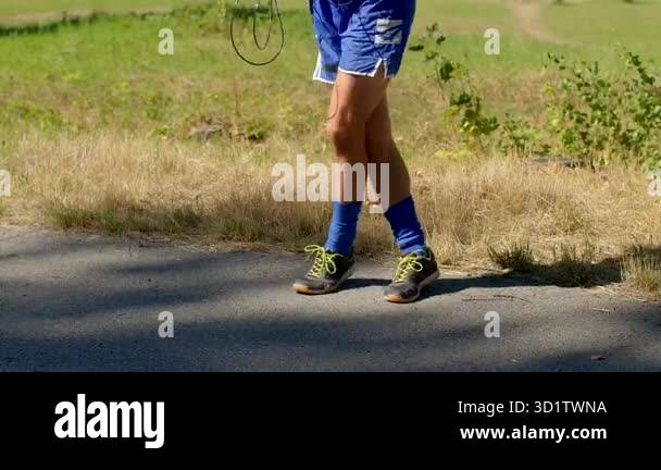 An athlete practices jump rope in blue shorts and matching socks on a ...