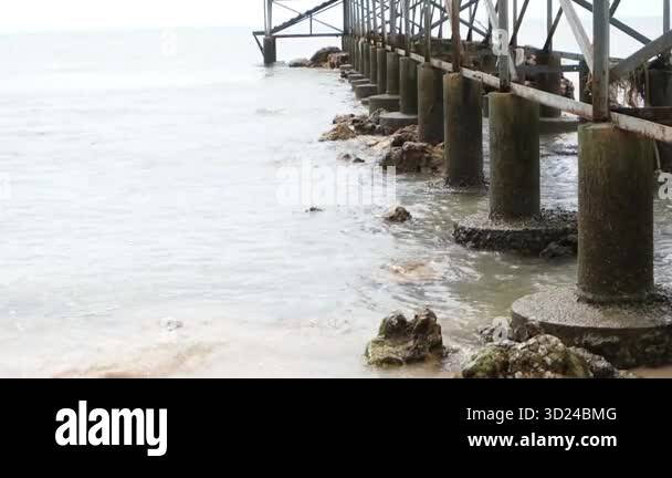 The waves of the sea hit the concrete pillars of the beach bridge Stock ...
