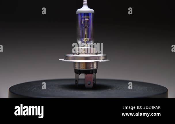 Halogen car bulb with H4 base. Rotates on a black background. Car bulb ...