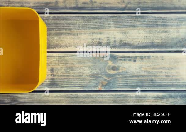 Yellow plastic container moving to center, filling with metal can and ...