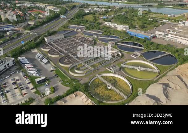 Eco-friendly aerial view of wastewater treatment plant near Lyon, France, with urban skyline ...