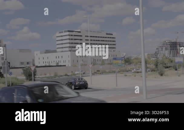 Cityscape with cars driving on a road near a modern hospital and ...