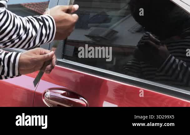 Close up of thief breaking into car using metal tool, symbolizing crime ...