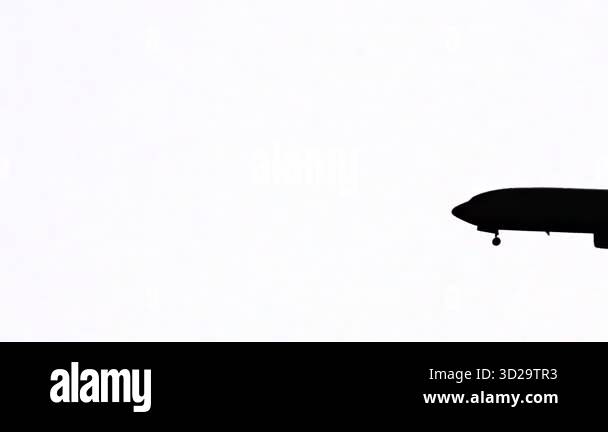 airplane flying overhead to land at airport in shadow and slow motion ...