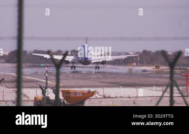 low angle shot of airplane flying overhead to land at airport in slow ...