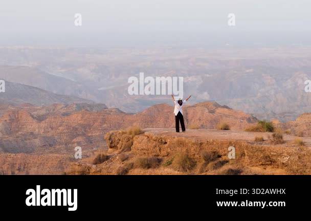 Muslim woman with her arms raised in success and freedom on top of a ...
