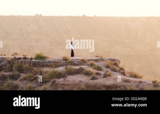 Aerial view of a woman in traditional clothing standing on the edge of ...