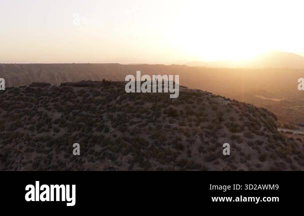 Aerial drone shot showing a muslim woman standing on a cliff edge ...