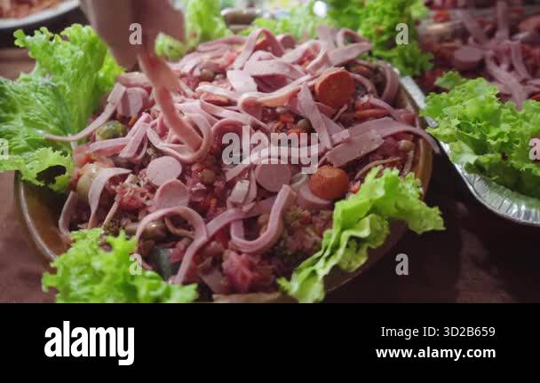 Hand dropping strips of ham over Guatemalan fiambre Stock Video Footage ...