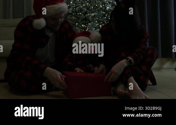 Family Opening Christmas Gift in Matching Pajamas Magic Moment Stock ...