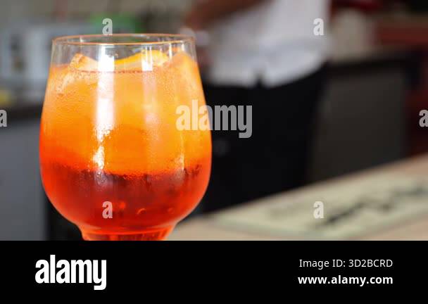 Chilled spritz cocktail with ice, accompanied by appetizer bowl ...