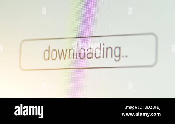 Close-up of a monitor screen with the words "downloading". On the ...