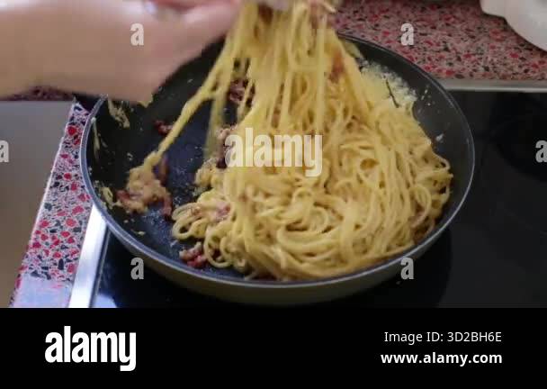 close up chef mixing pasta carbonara ingredients in frying pan Stock ...