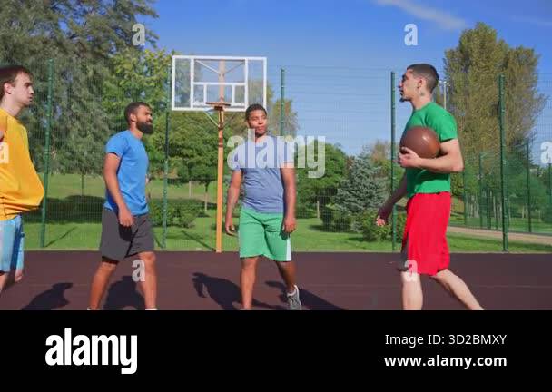 Motivated athletic fit diverse multi ethnic male basketball players with ball giving high five ...