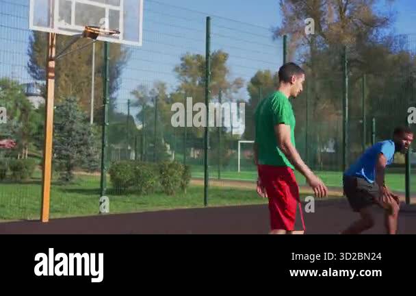 Active sporty fit male basketball player receiving assist from African ...