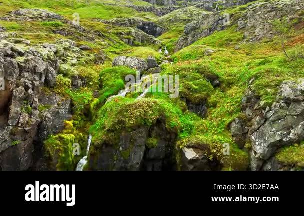 Wispy waterfalls flowing over cliff, Mountain river falling over cliff ...