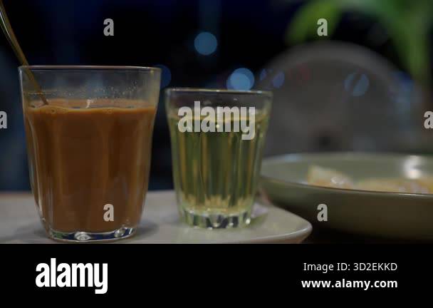 Hot Thai tea and roti drinks at a night shop with lights and bokeh ...