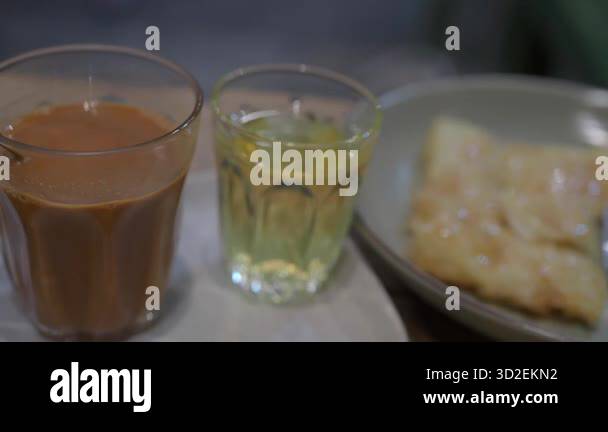 Hot Thai tea and roti drinks at a night shop with lights and bokeh ...