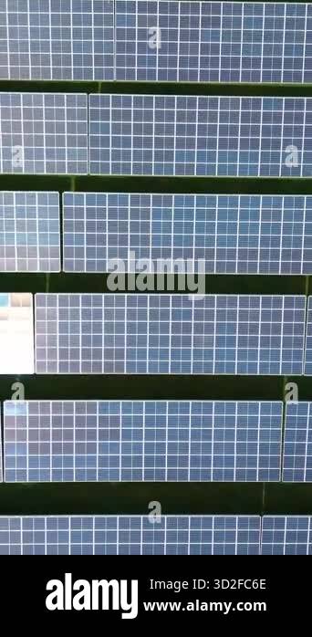 Overhead aerial view of a solar farm with rows of photovoltaic panels ...
