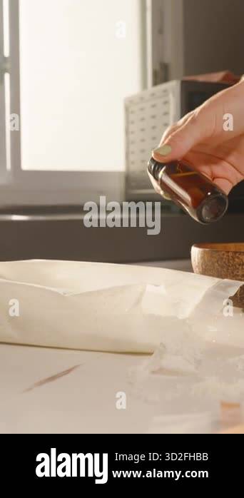 Vertical video. Close up of female hand holding small amber essential ...