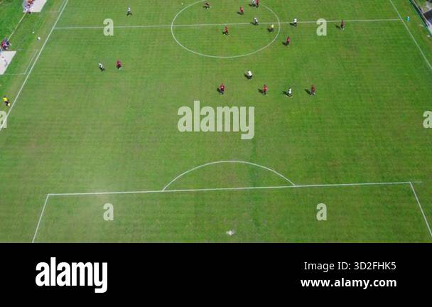 Drone footage showing football players moving and passing the ball near ...