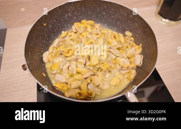 Mussels Cooking in Oil and Garlic in Frying Pan with Hot Liquid in Slow ...